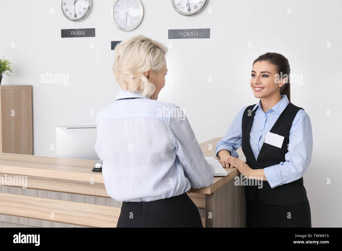 Female receptionist teaching trainee in hotel Stock Photo - Alamy