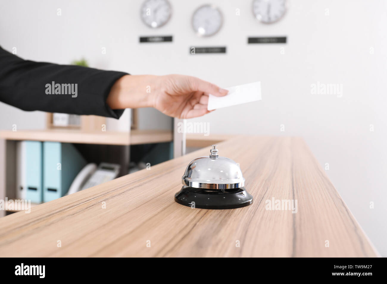 Female receptionist with card in hotel Stock Photo - Alamy