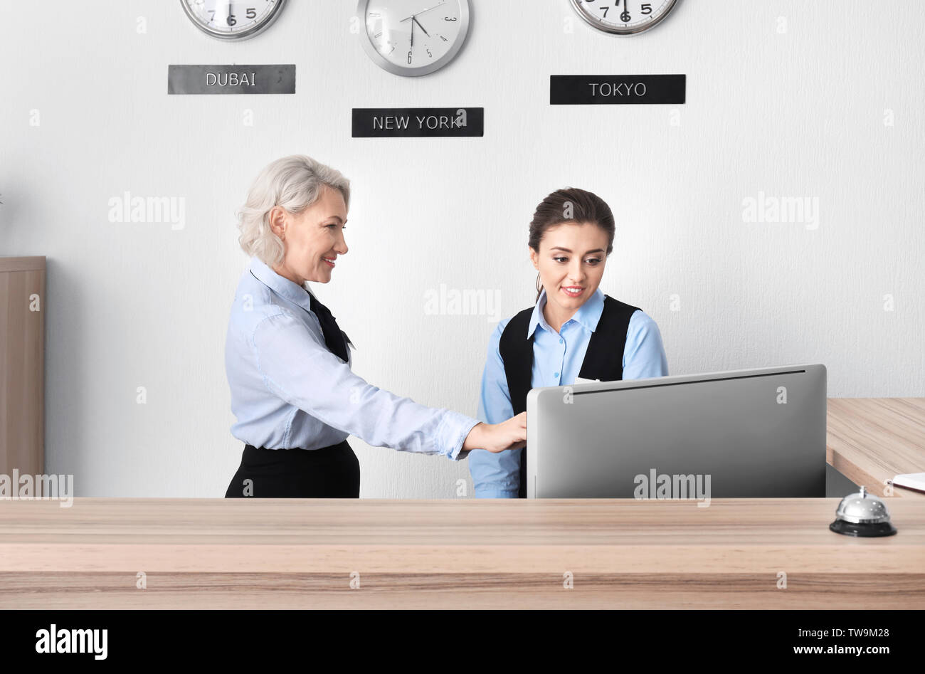 Female receptionist teaching trainee in hotel Stock Photo - Alamy