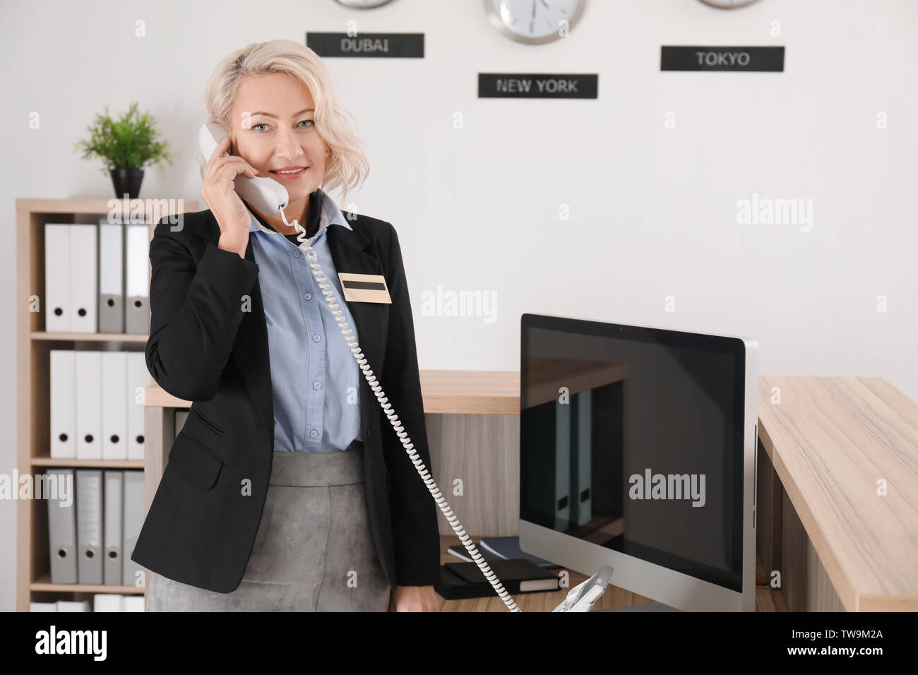 Female receptionist talking on phone in hotel Stock Photo - Alamy