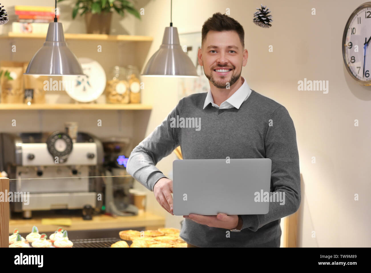 Business owner with laptop in his bakery Stock Photo - Alamy