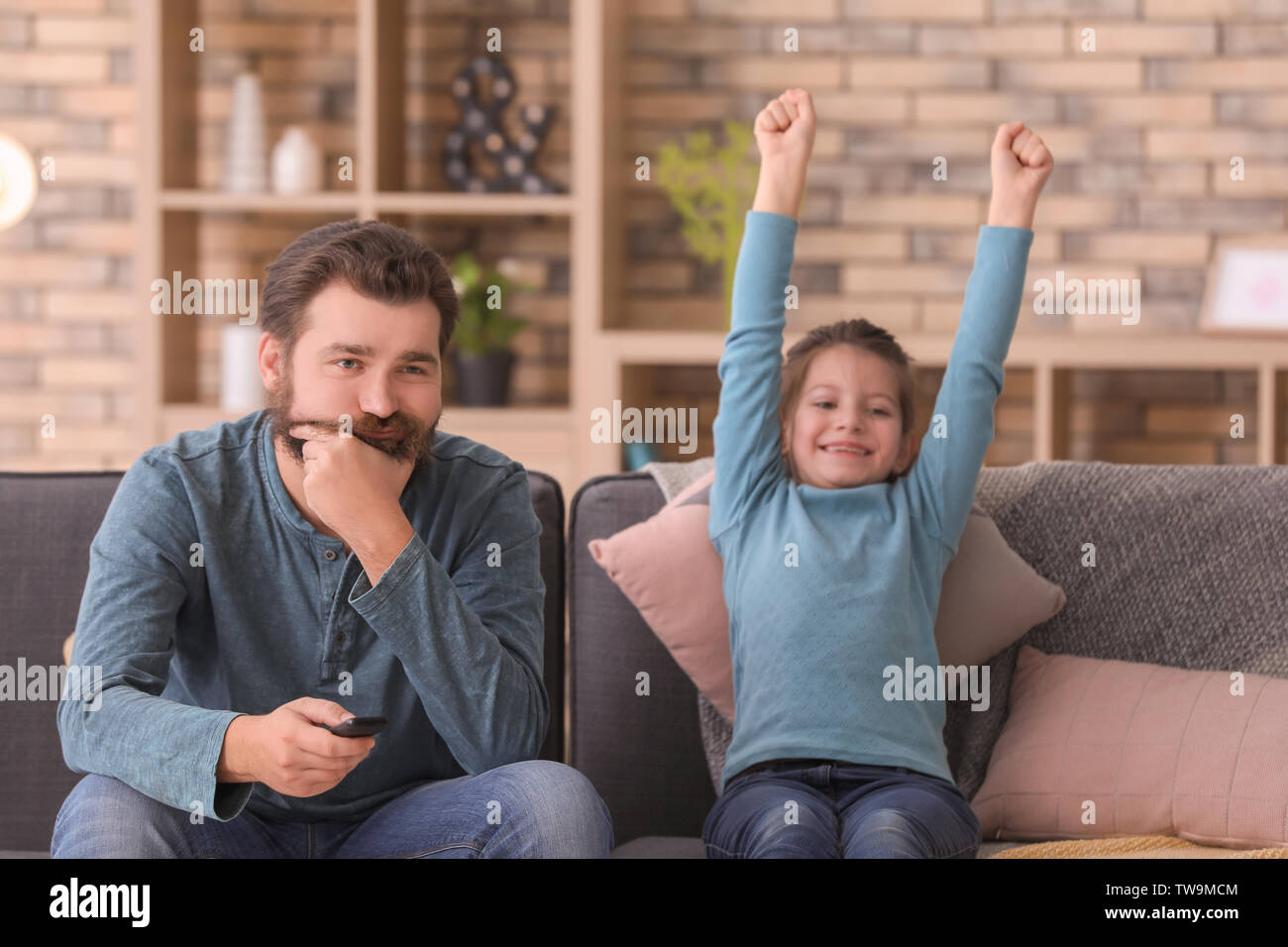 Father and daughter watching TV together at home Stock Photo - Alamy