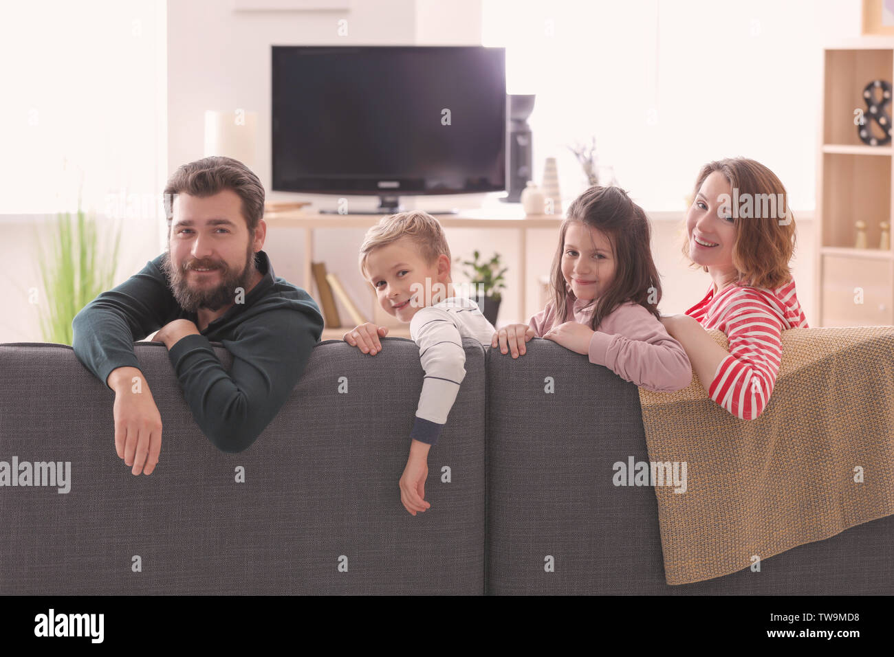 Portrait of happy family watching TV at home Stock Photo - Alamy