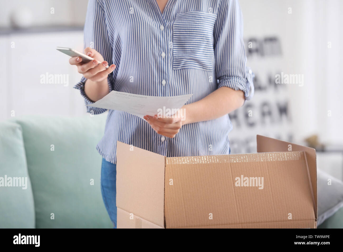 Young woman making call about delivered parcel at home Stock Photo - Alamy
