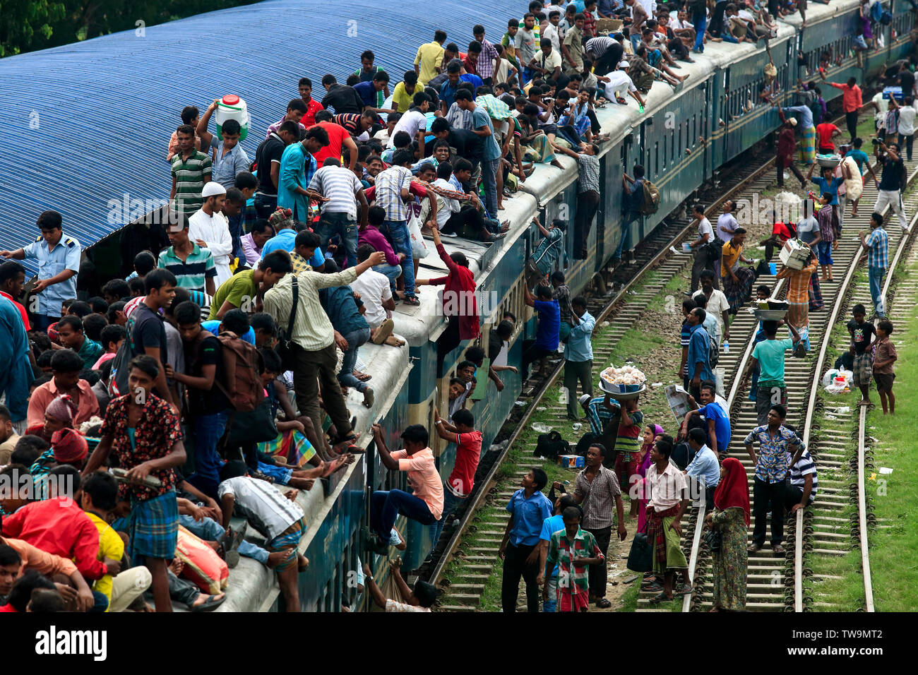 Home-bound people struggle to get the rooftop of the train at Airport ...