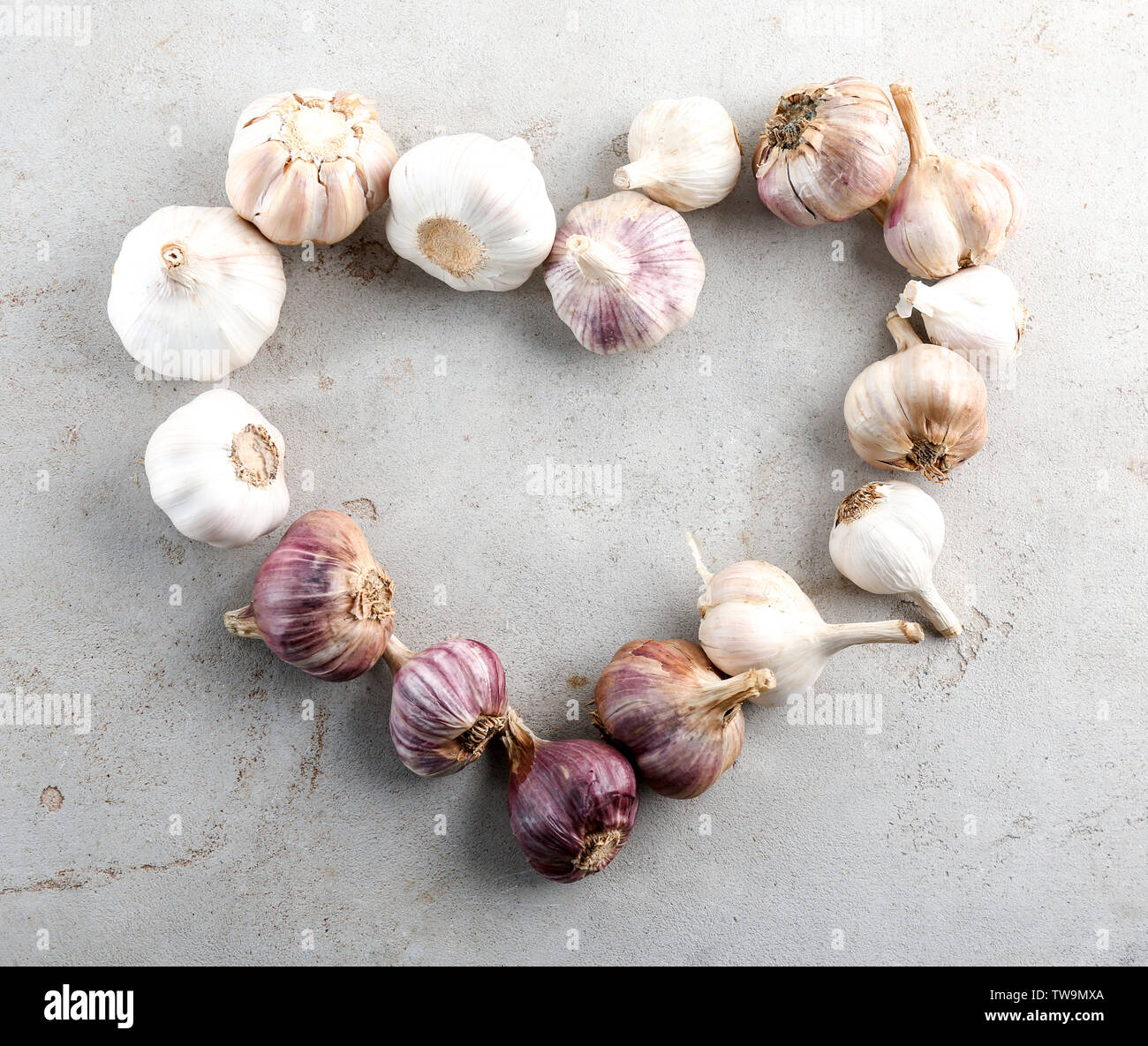 Heart shape of fresh garlic heads on grey background Stock Photo - Alamy