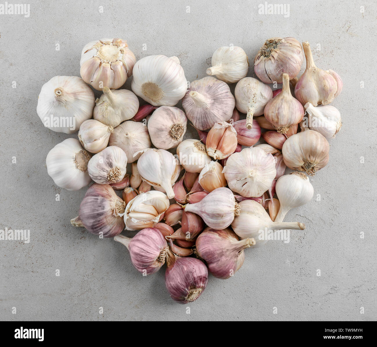 Heart shape of fresh garlic heads on grey background Stock Photo - Alamy