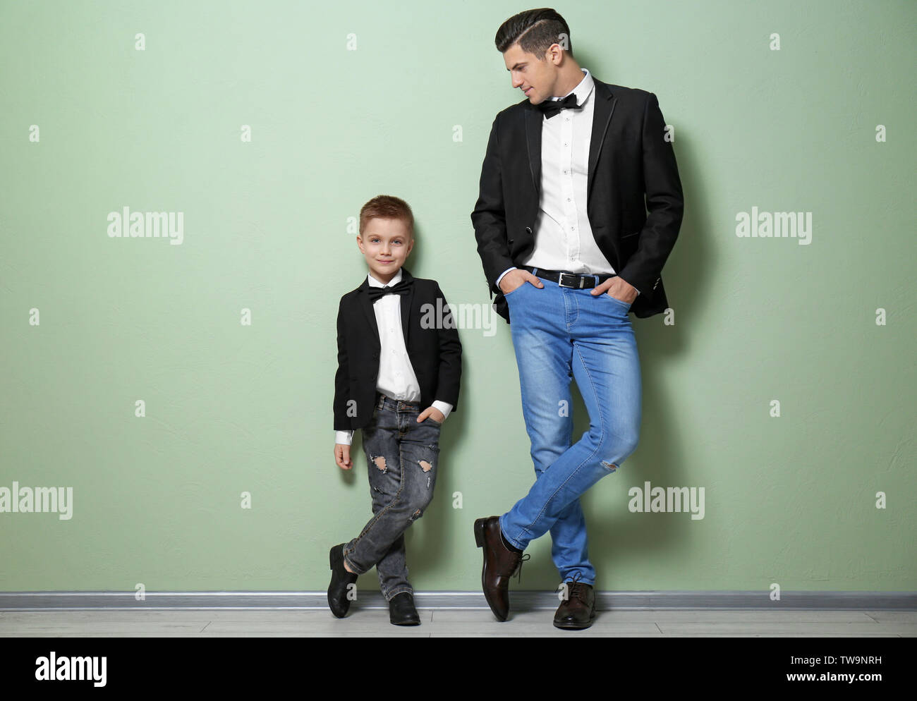 Stylish father and son in jackets against color wall Stock Photo - Alamy