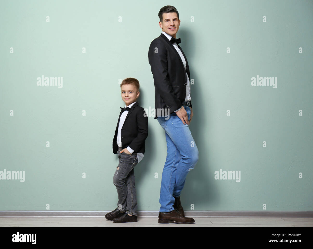 Stylish father and son in jackets against color wall Stock Photo - Alamy
