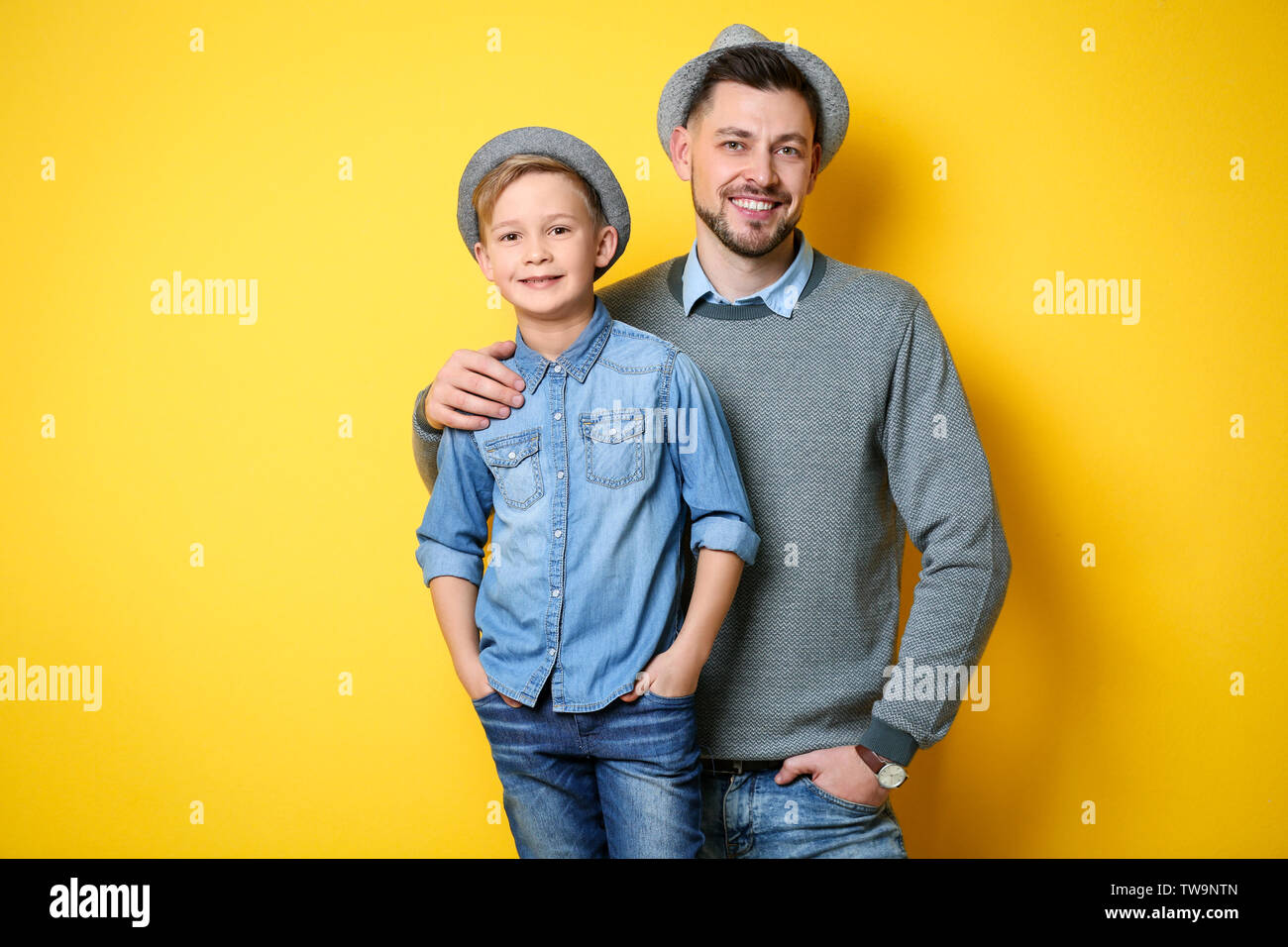 Stylish father and son on color background Stock Photo - Alamy