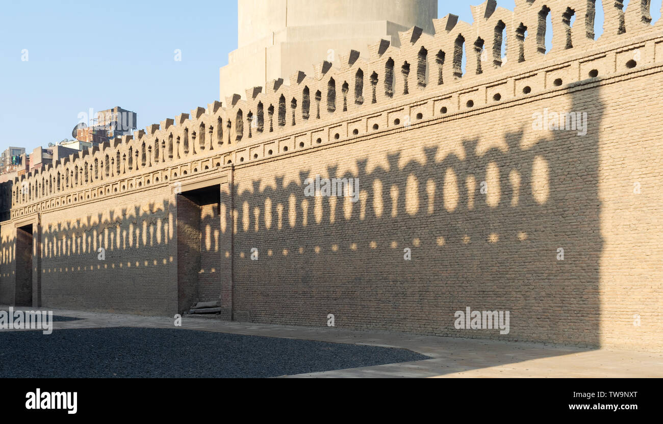 Stone bricks old decorated fence with wooden door and shadows of ...