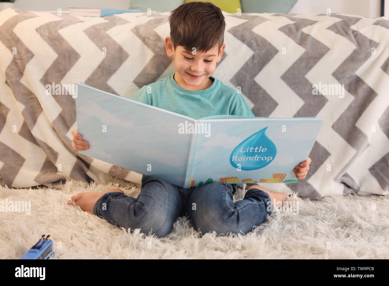 Cute little boy reading book at home Stock Photo - Alamy