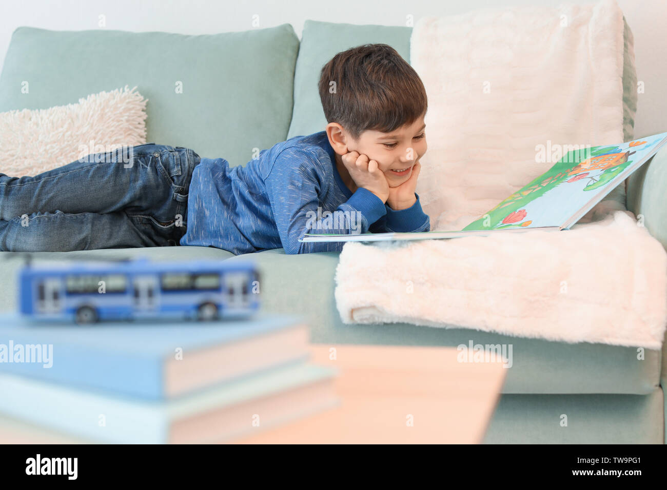 Cute little boy reading book at home Stock Photo - Alamy