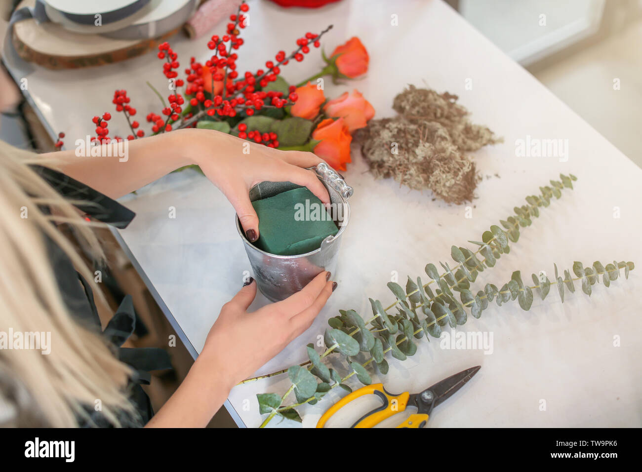 Female florist using sponge for work in flower shop Stock Photo - Alamy