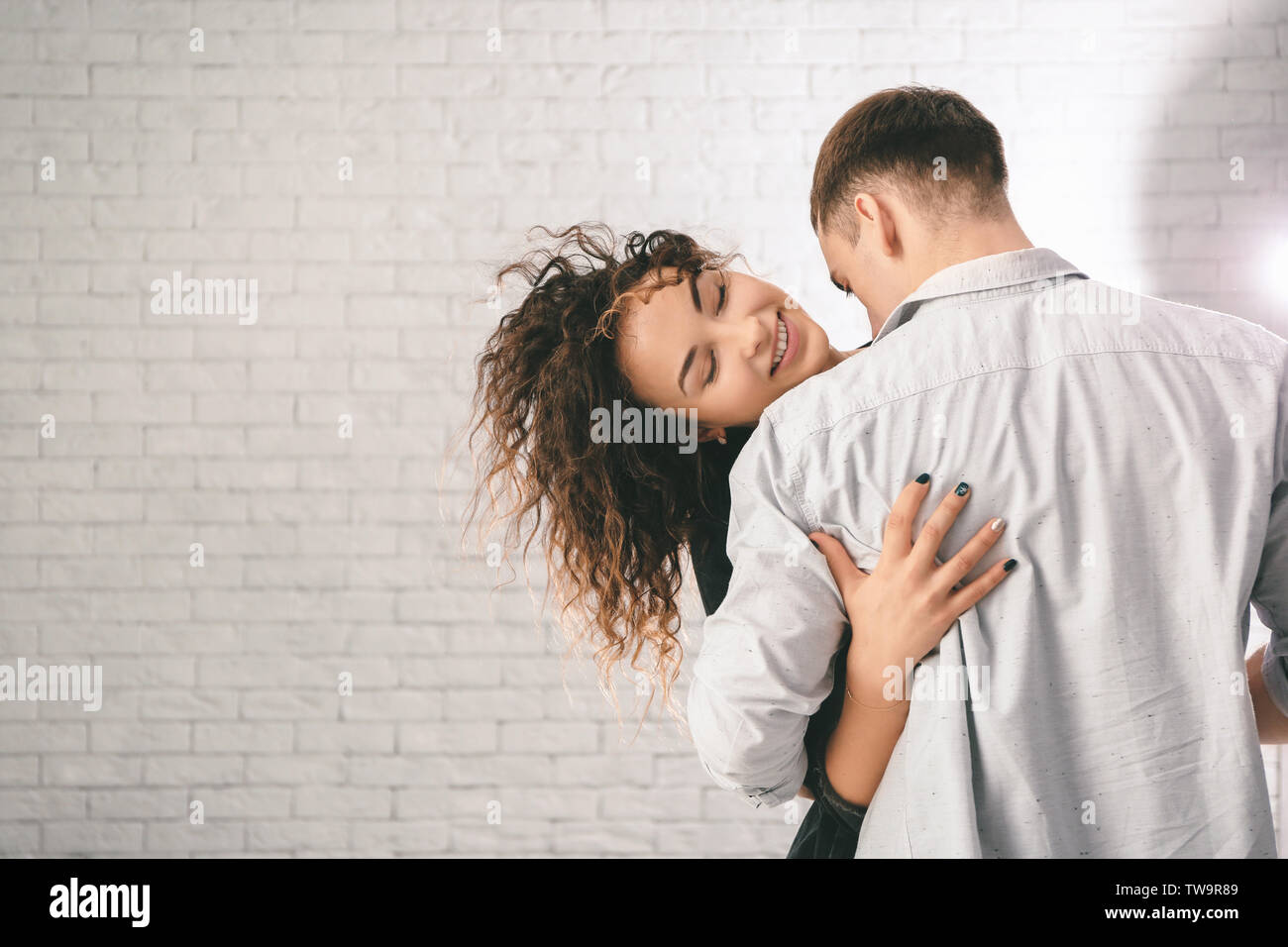 Couple hugging against wall hi-res stock photography and images - Alamy