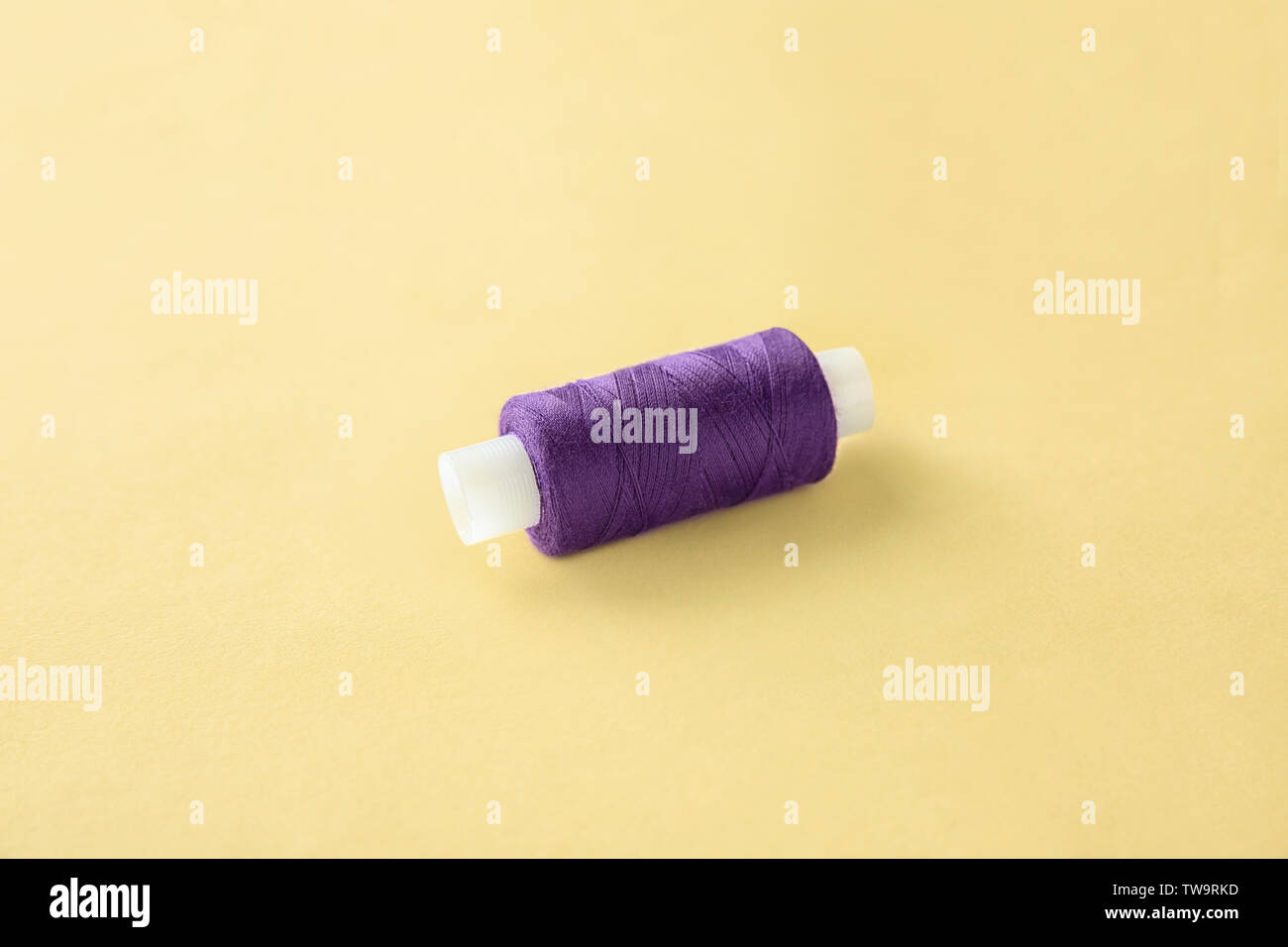 Purple sewing thread on light background Stock Photo - Alamy