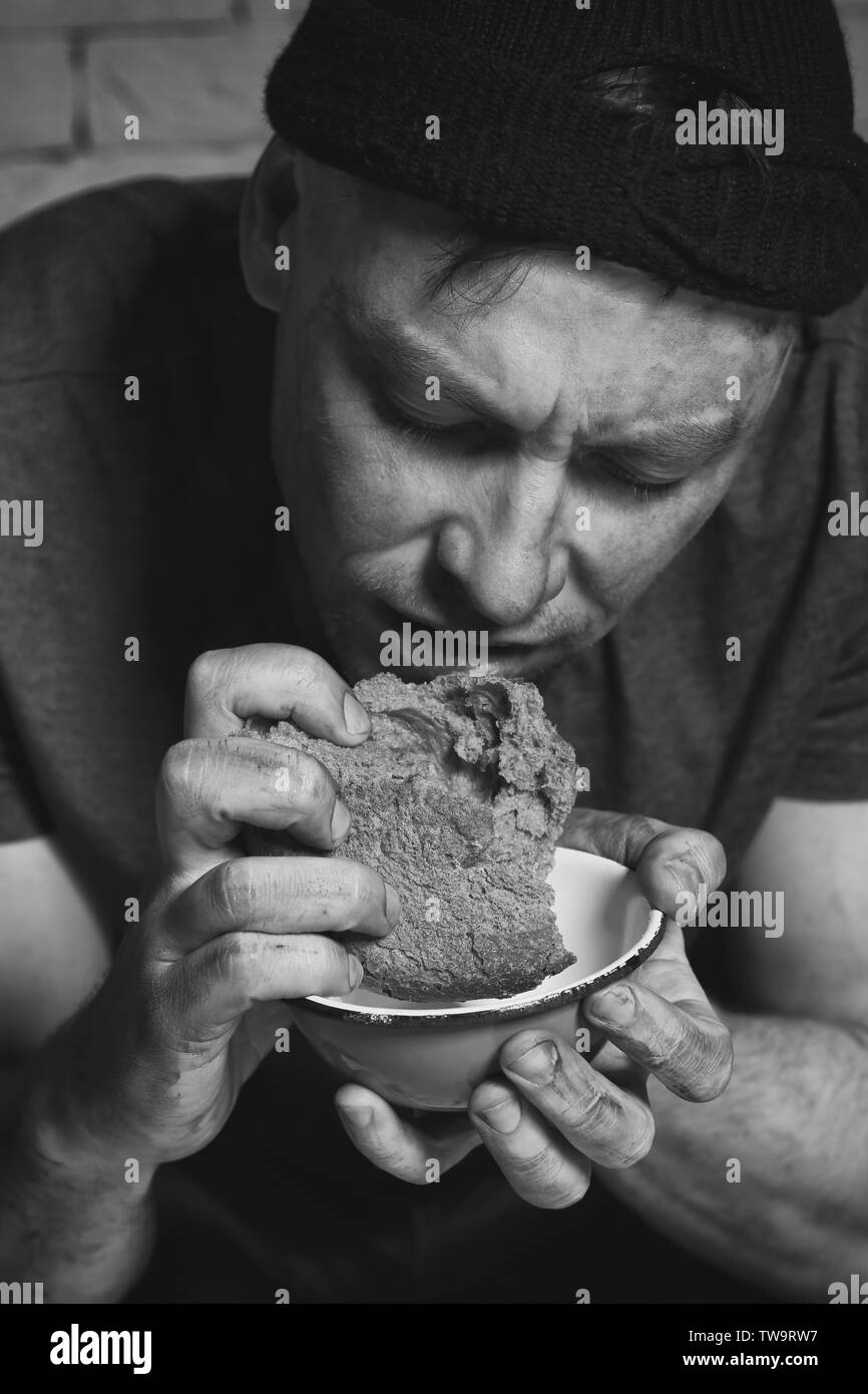 Hungry poor man eating piece of bread Stock Photo - Alamy