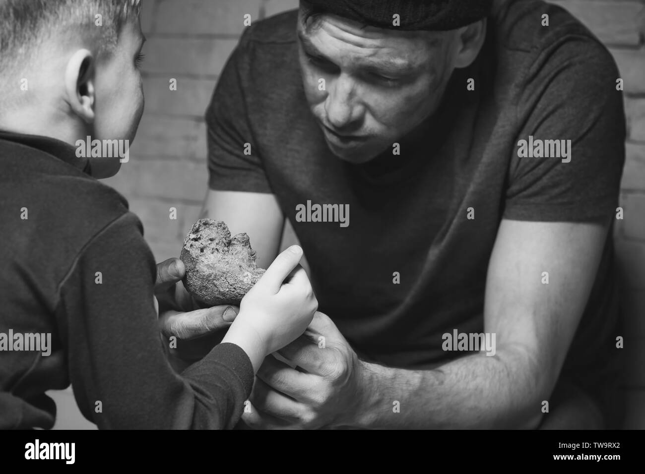 Little child giving piece of bread to homeless poor man Stock Photo - Alamy