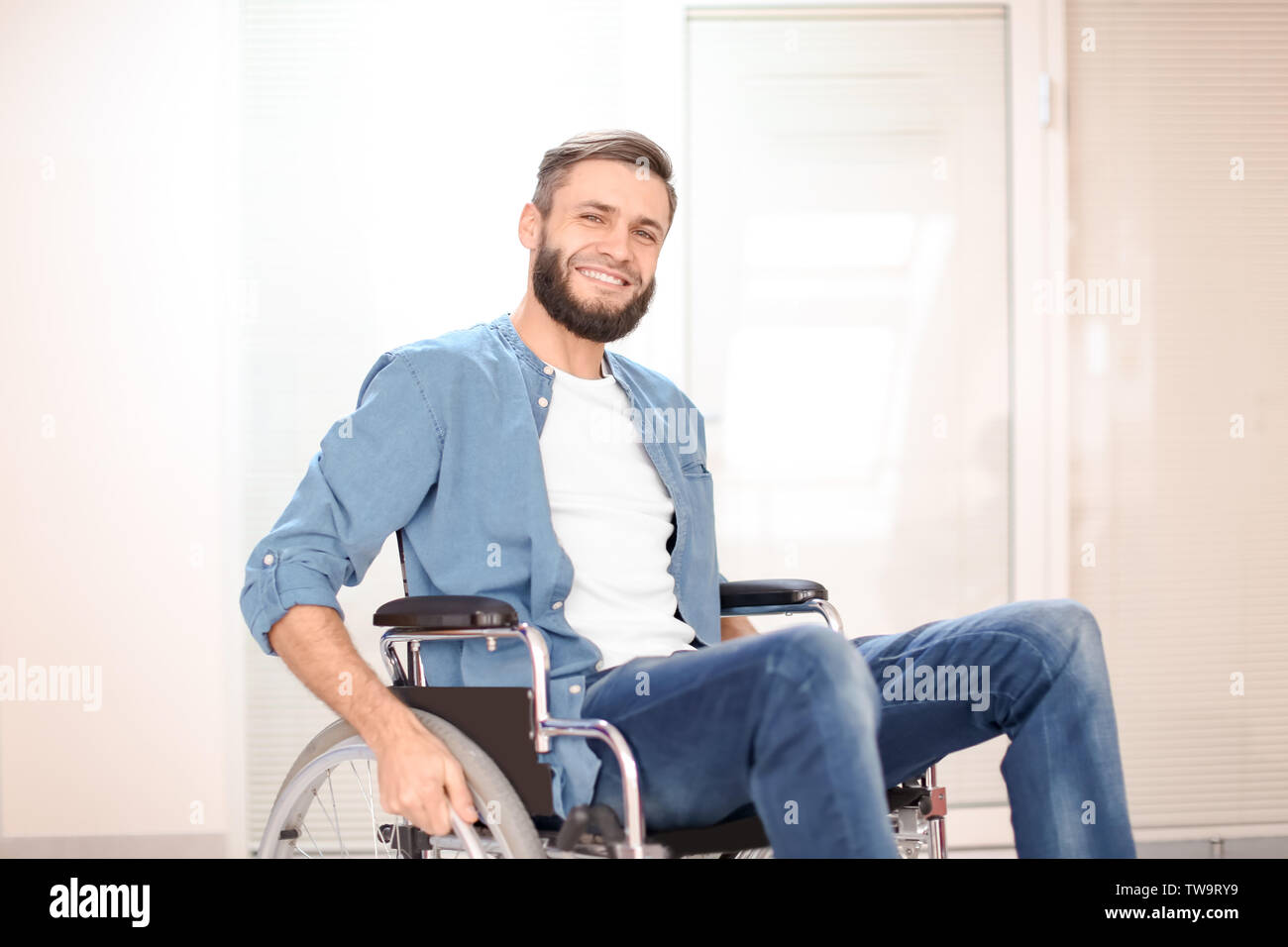 Man sitting in wheelchair indoors Stock Photo - Alamy