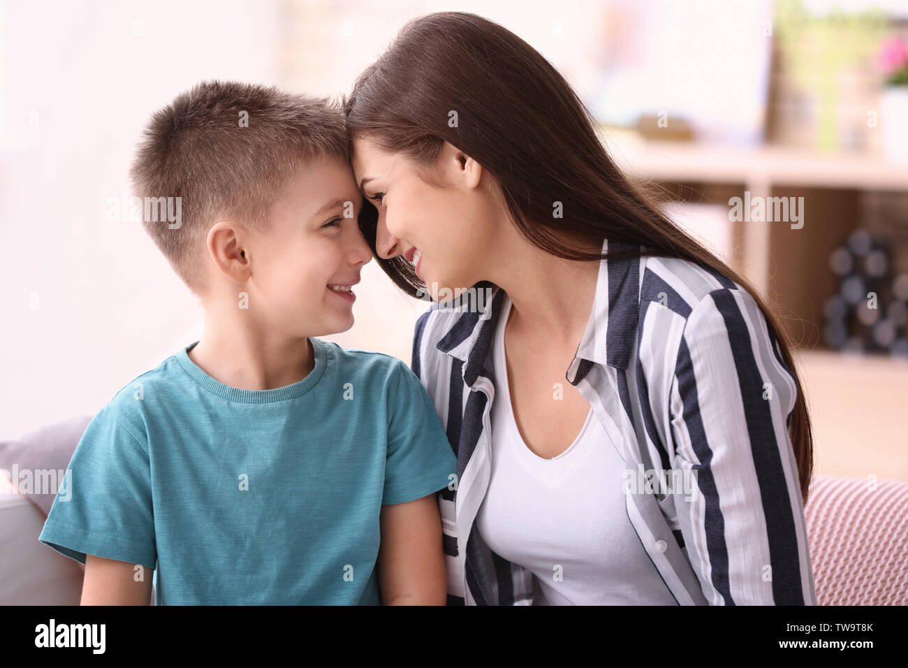 Young woman with little boy indoors. Child adoption Stock Photo - Alamy