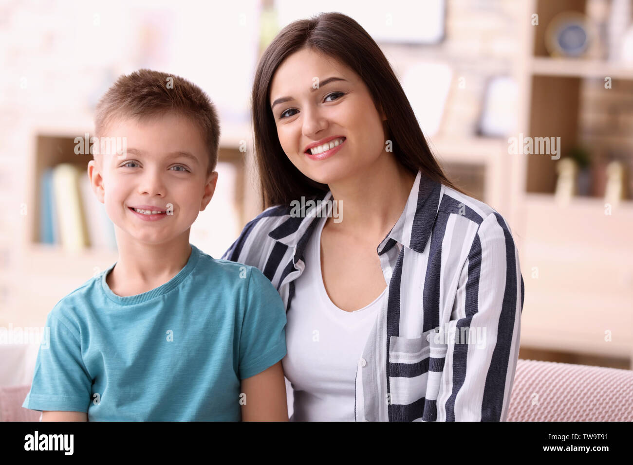 Young woman with little boy indoors. Child adoption Stock Photo - Alamy