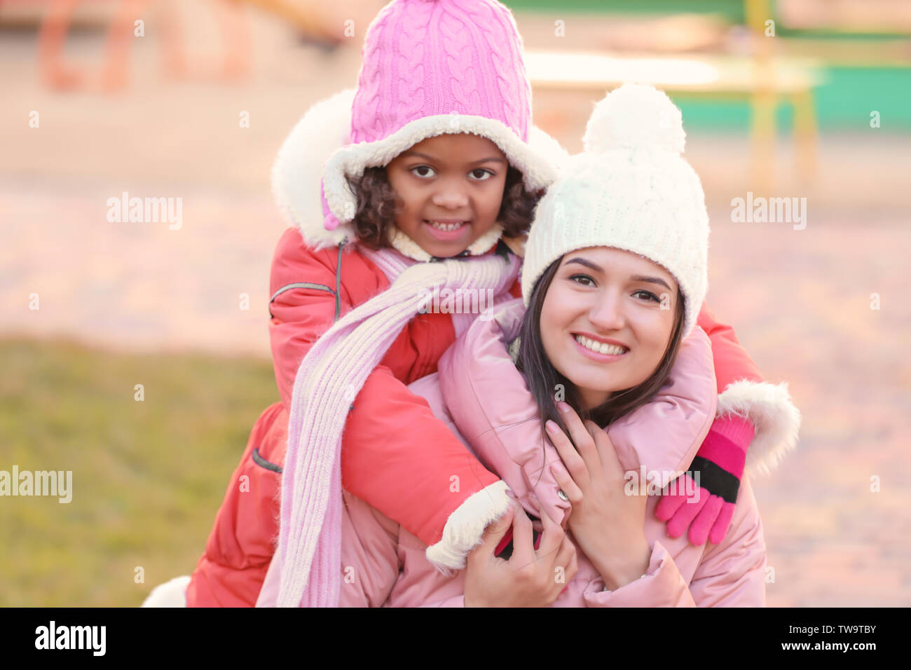 Young woman with little African-American girl outdoors. Child adoption ...