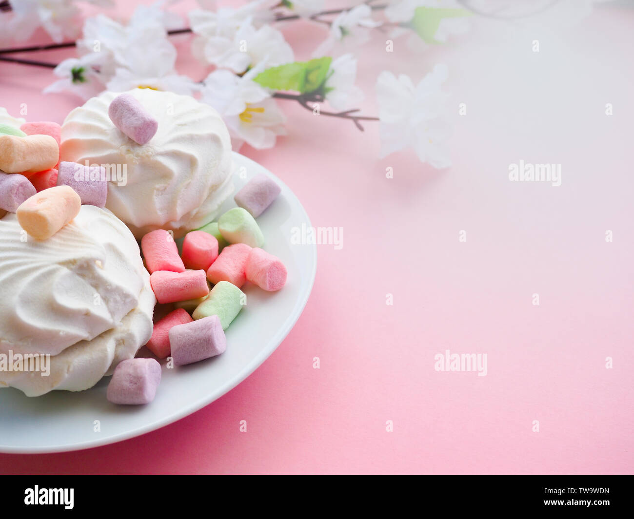 Marshmallow in white plate on pink background Stock Photo - Alamy