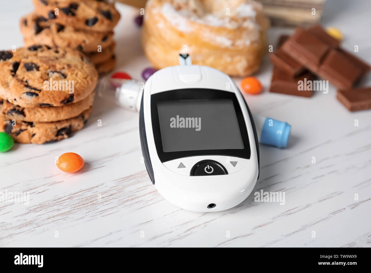 Digital glucometer and sweets on table. Diabetes concept Stock Photo ...