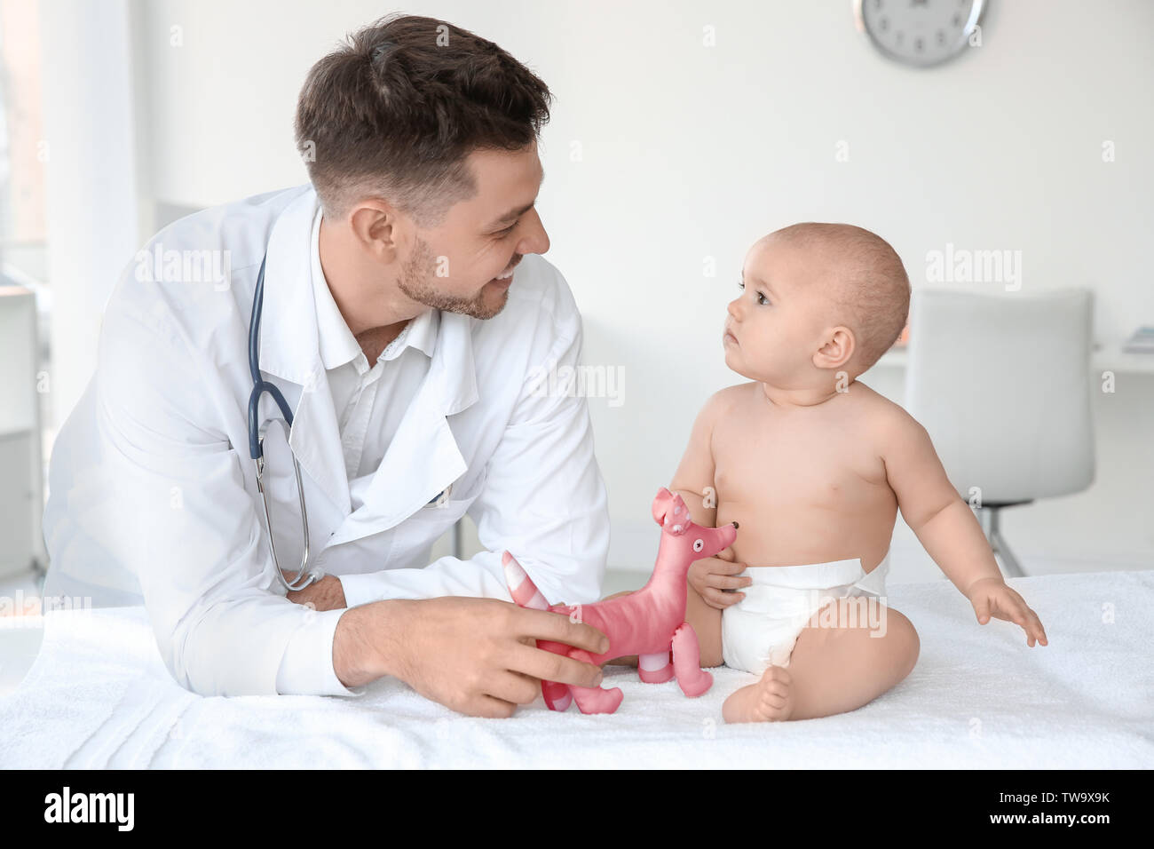 Doctor examining cute baby in clinic Stock Photo - Alamy