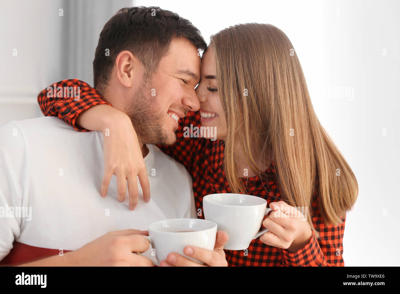 Cute young lovely couple drinking tea at home Stock Photo - Alamy