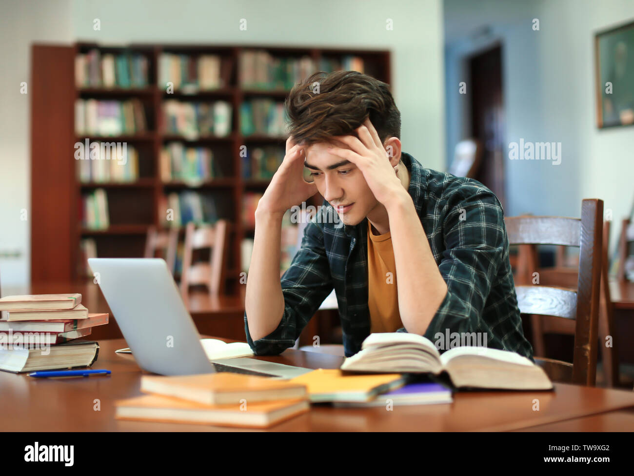 Student with laptop studying in library Stock Photo - Alamy