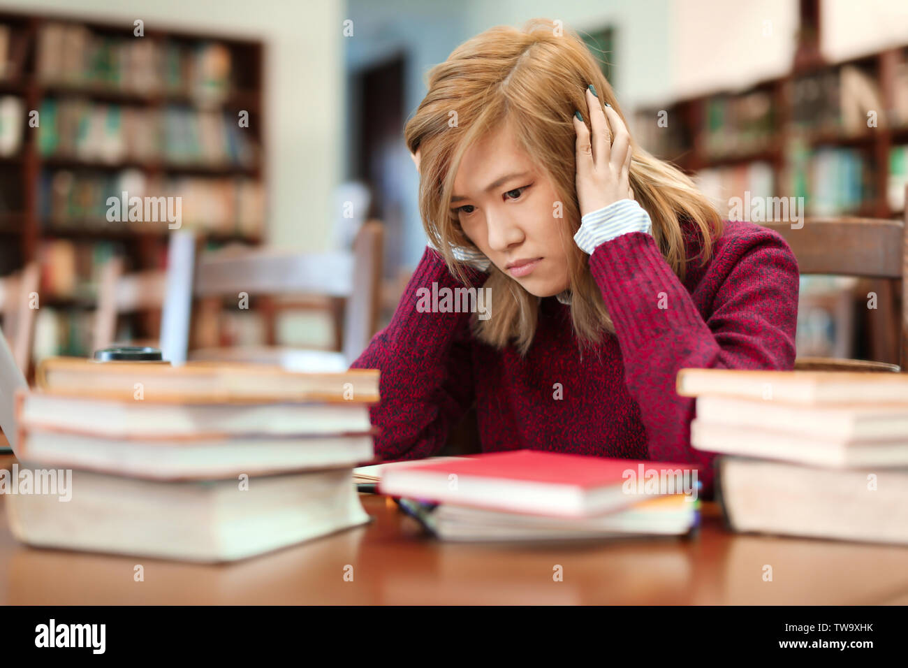 Asian student with books studying in library Stock Photo - Alamy