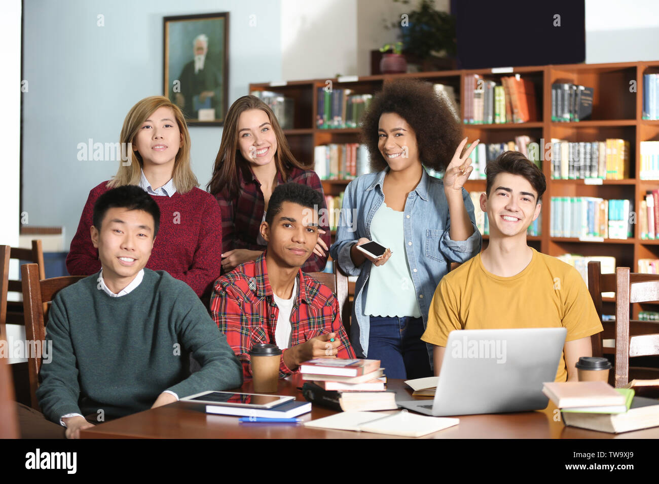 Group of students studying at table in library Stock Photo - Alamy