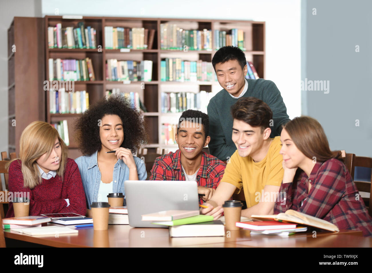 Group of students studying at table in library Stock Photo - Alamy