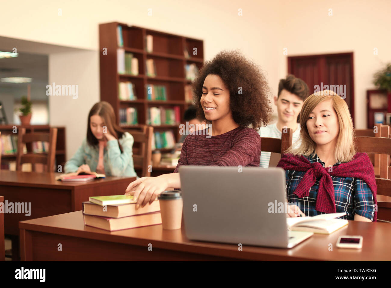 Group of students studying in library Stock Photo - Alamy