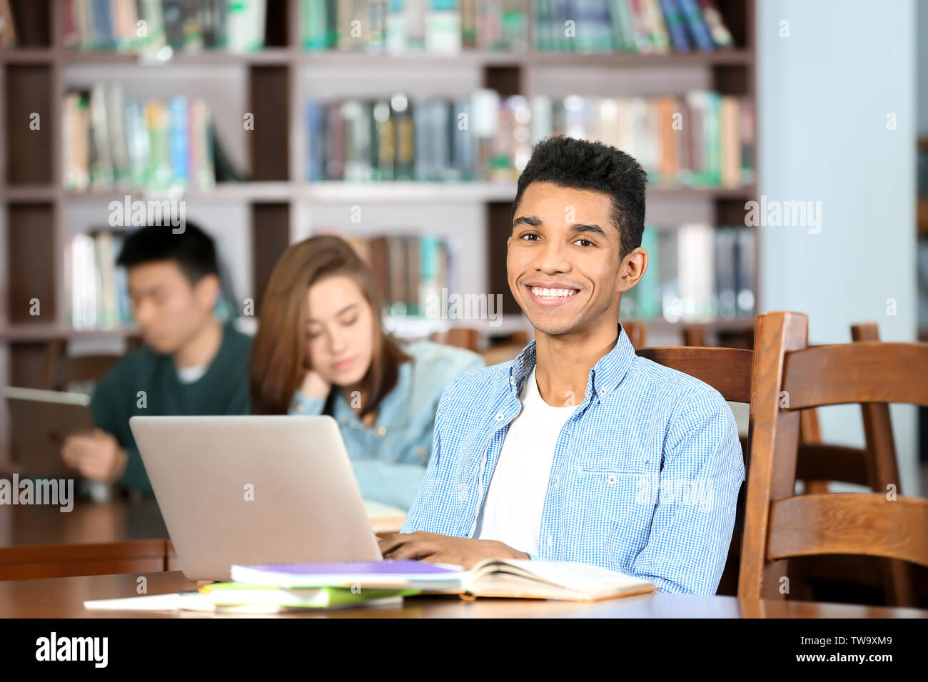 African American student with laptop studying in library Stock Photo ...