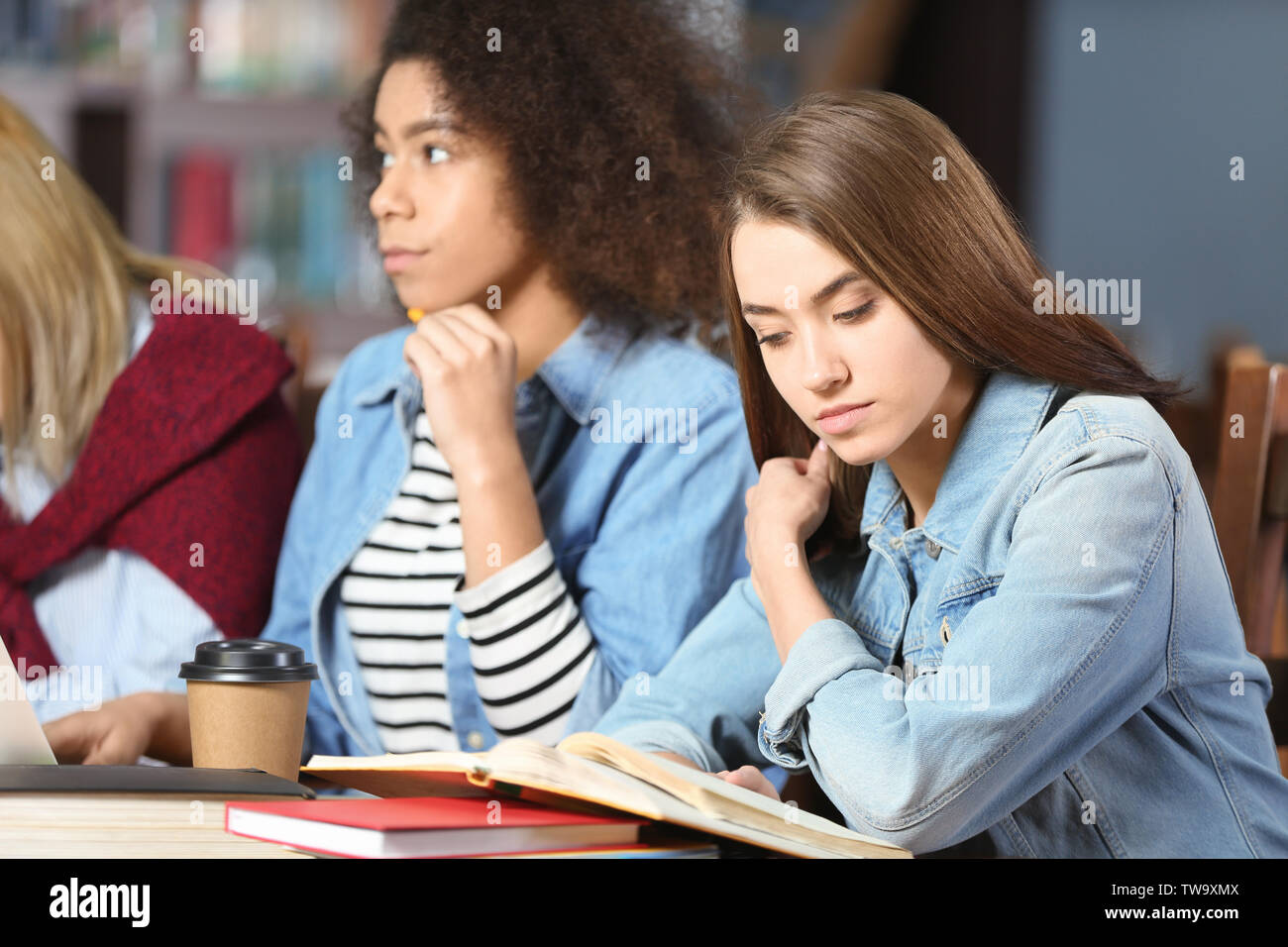 Group of students studying at table in library Stock Photo - Alamy
