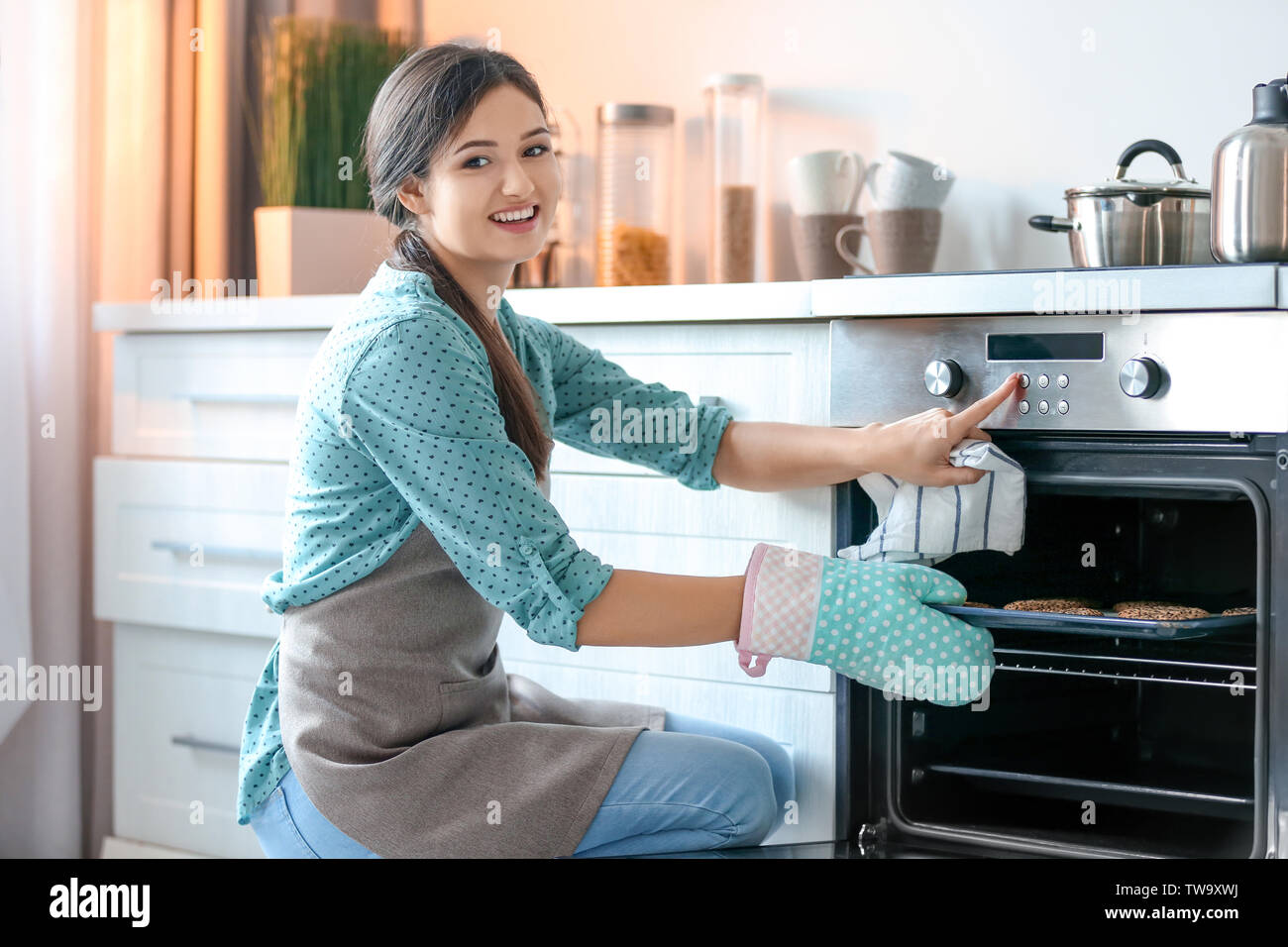 Woman baking cookies in oven indoors Stock Photo - Alamy