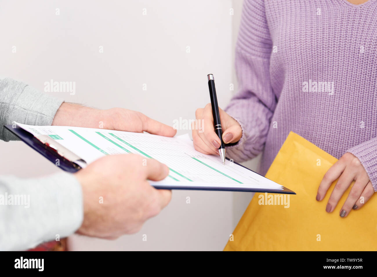 Woman signing for parcel delivery, closeup Stock Photo - Alamy