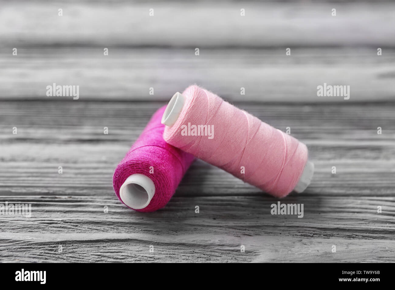Colorful sewing threads on wooden background Stock Photo - Alamy