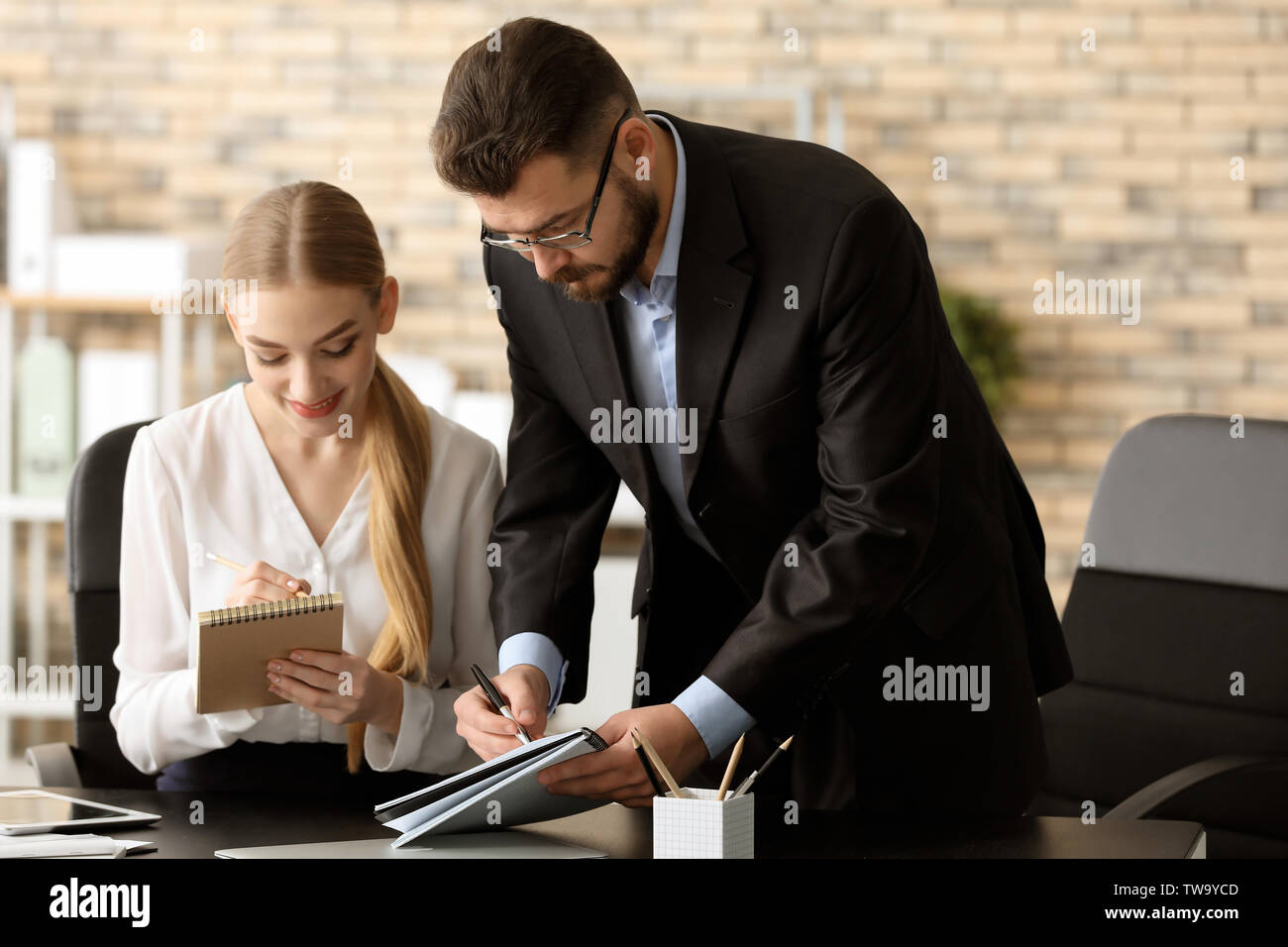 Male receptionist with trainee at workplace Stock Photo - Alamy
