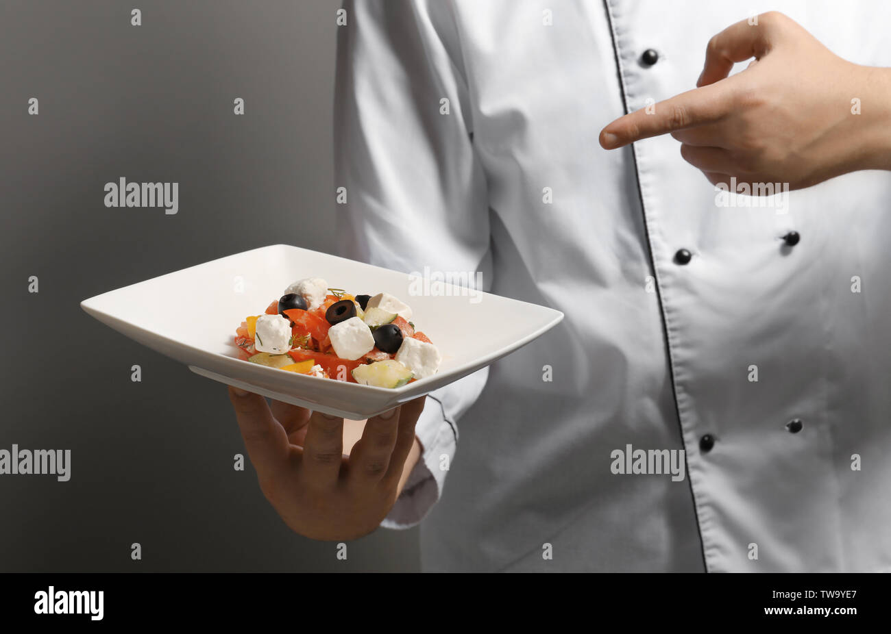 Male chef holding plate with dish, closeup Stock Photo - Alamy