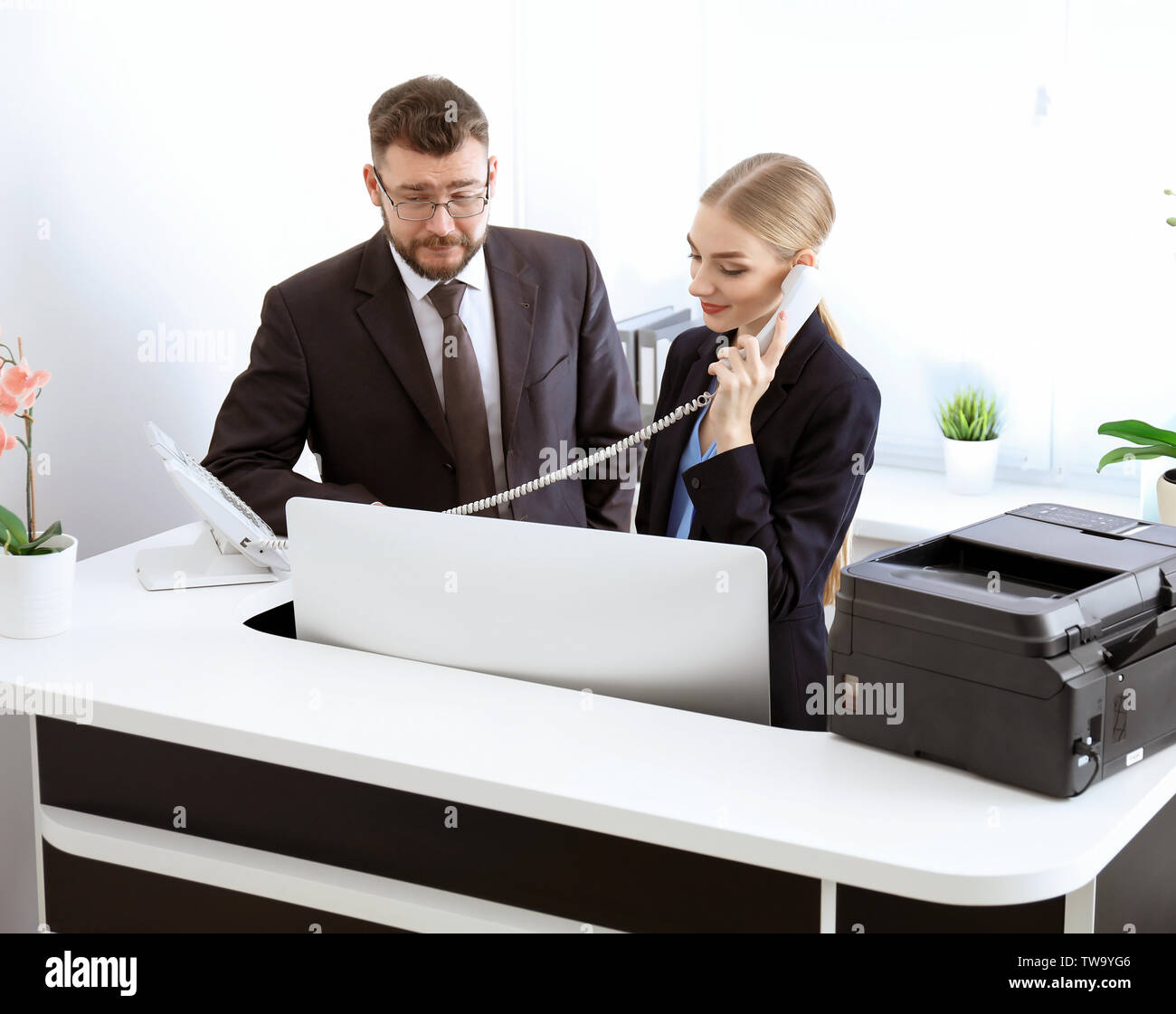 Male receptionist with trainee at workplace Stock Photo - Alamy