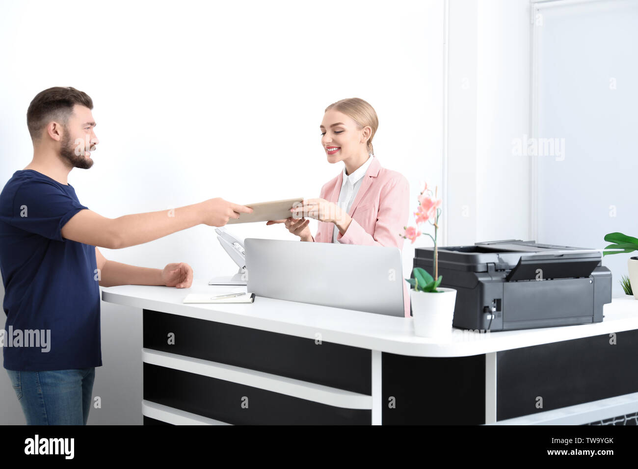 Female receptionist receiving parcel at workplace Stock Photo - Alamy