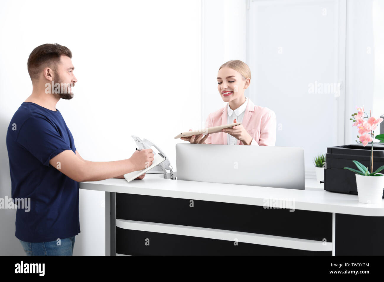 Female receptionist receiving parcel at workplace Stock Photo - Alamy