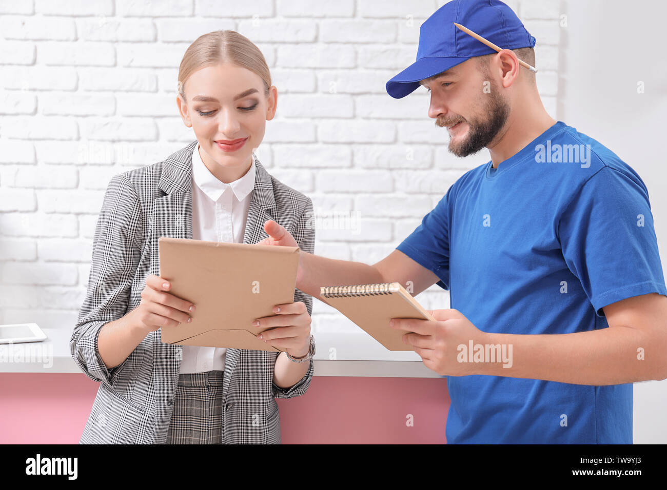 Female receptionist receiving parcel at workplace Stock Photo - Alamy