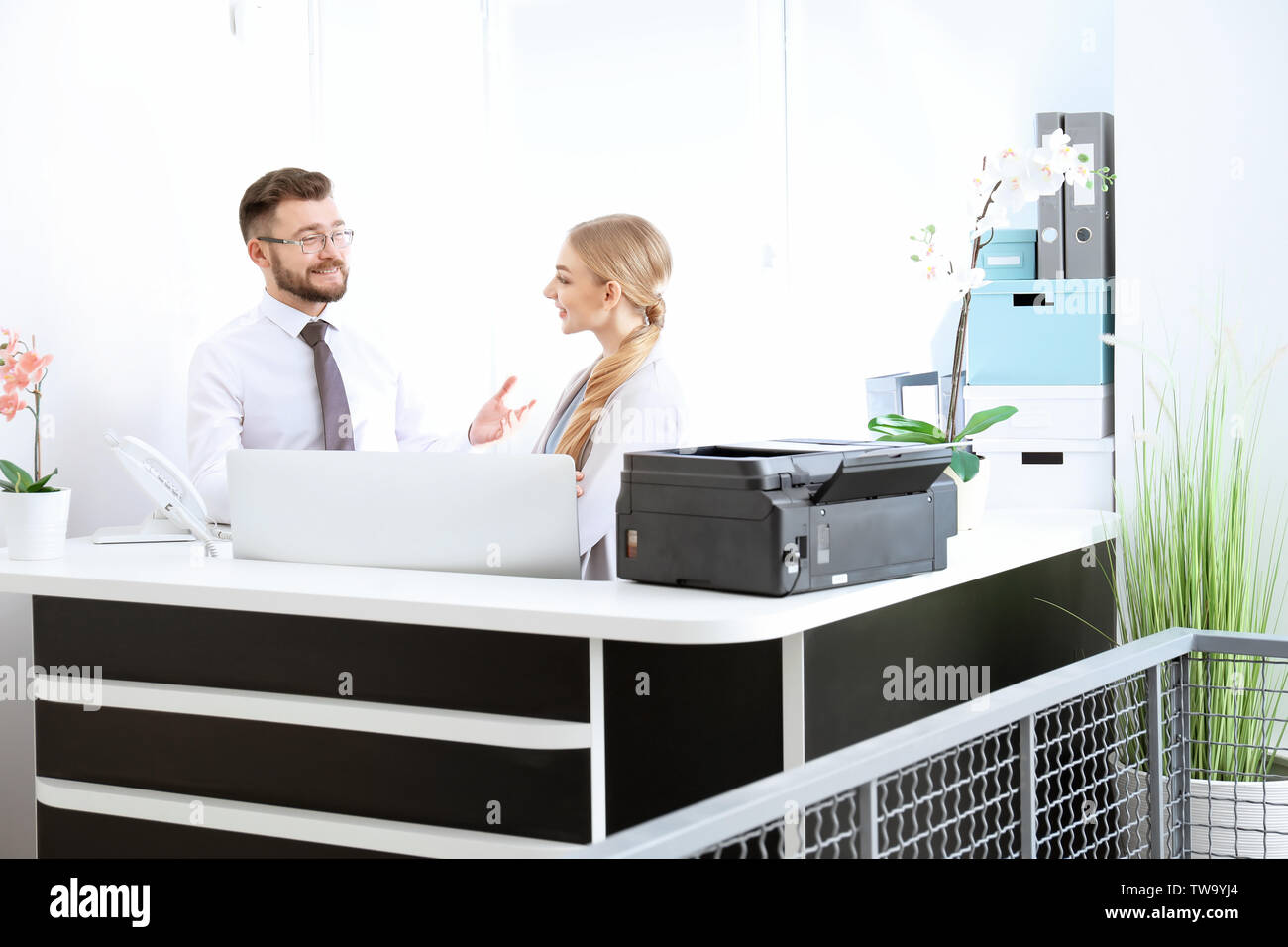Male receptionist with trainee at workplace Stock Photo - Alamy