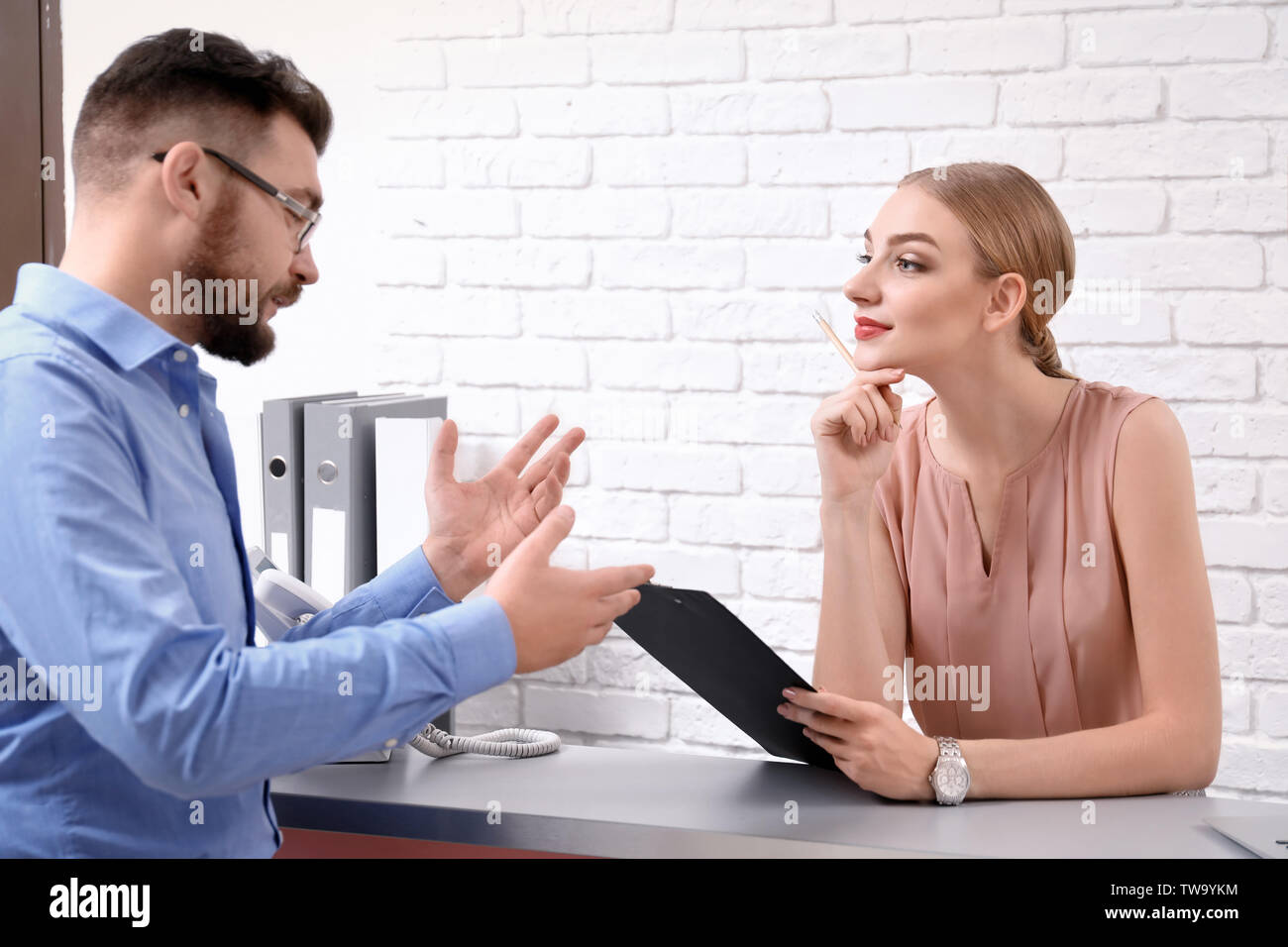 Male receptionist with trainee at workplace Stock Photo - Alamy