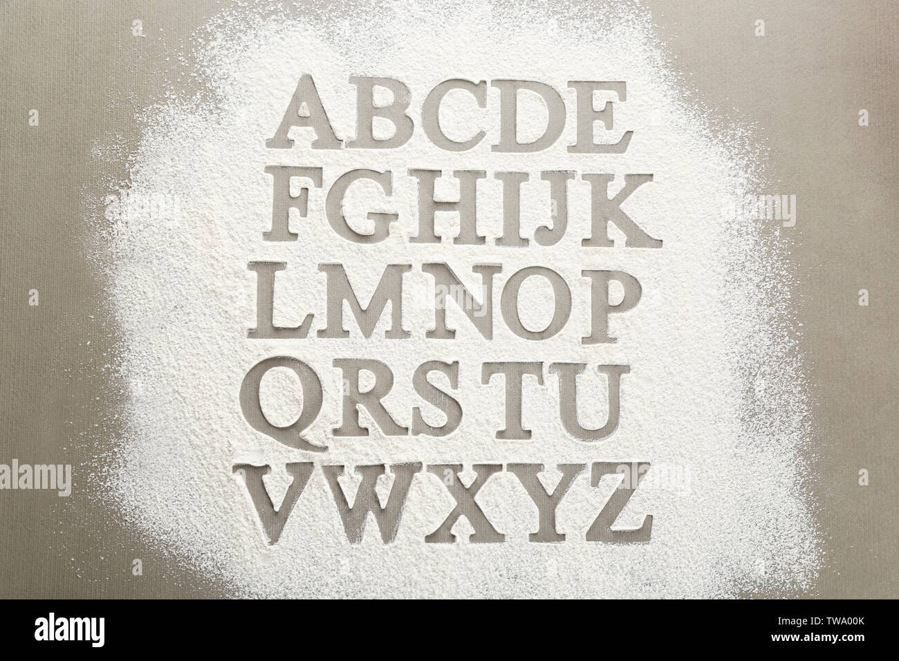 Silhouettes of alphabet letters on scattered flour Stock Photo - Alamy