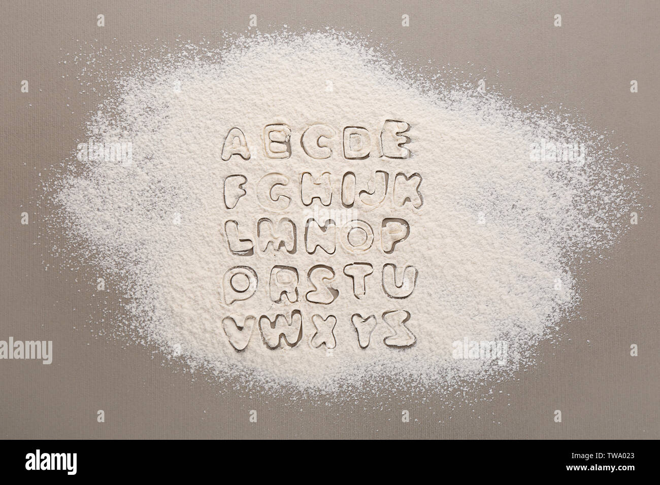 Silhouettes of alphabet letters on scattered flour Stock Photo - Alamy